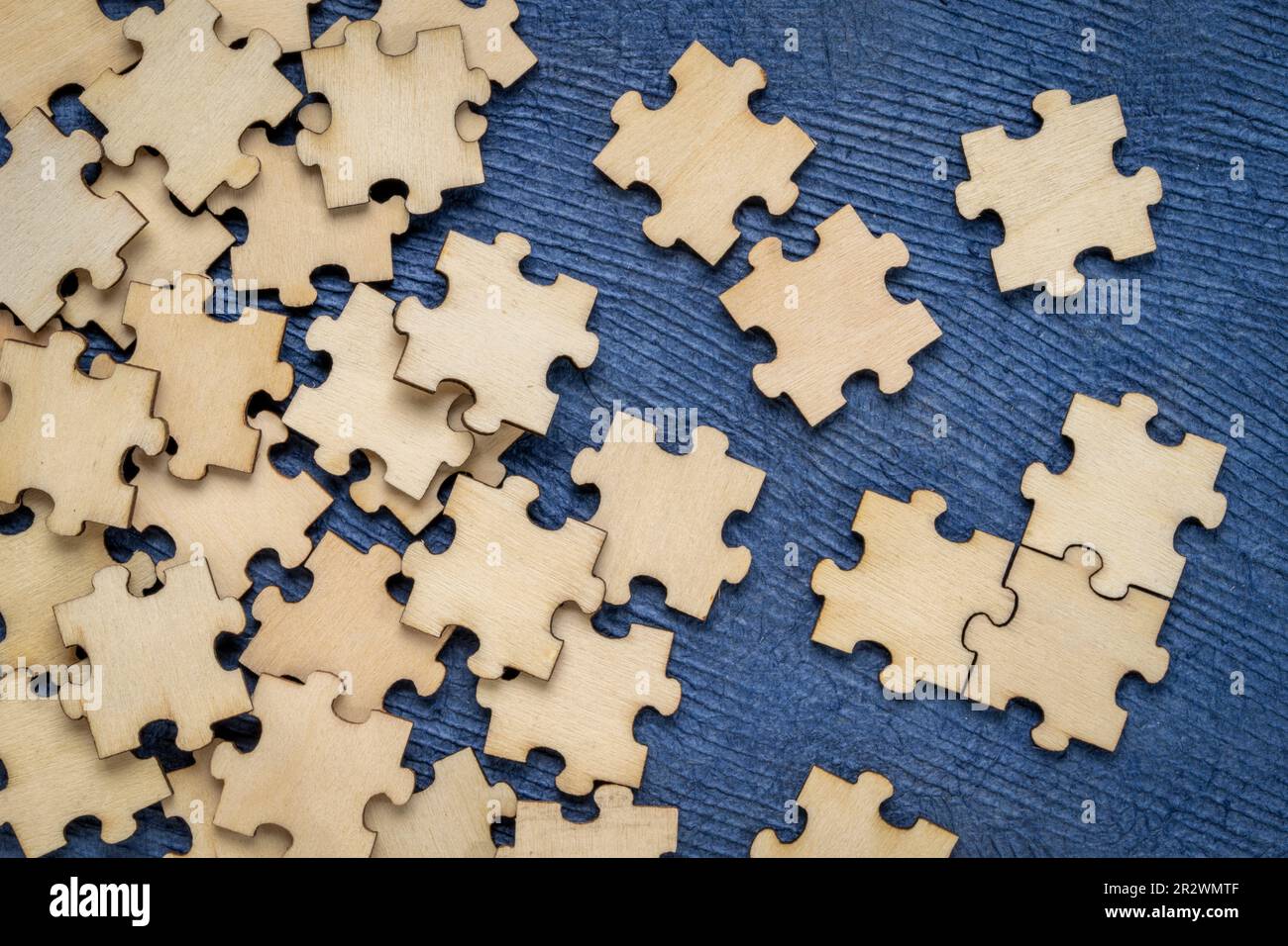 background of blank wooden jigsaw puzzle pieces on blue paper ...