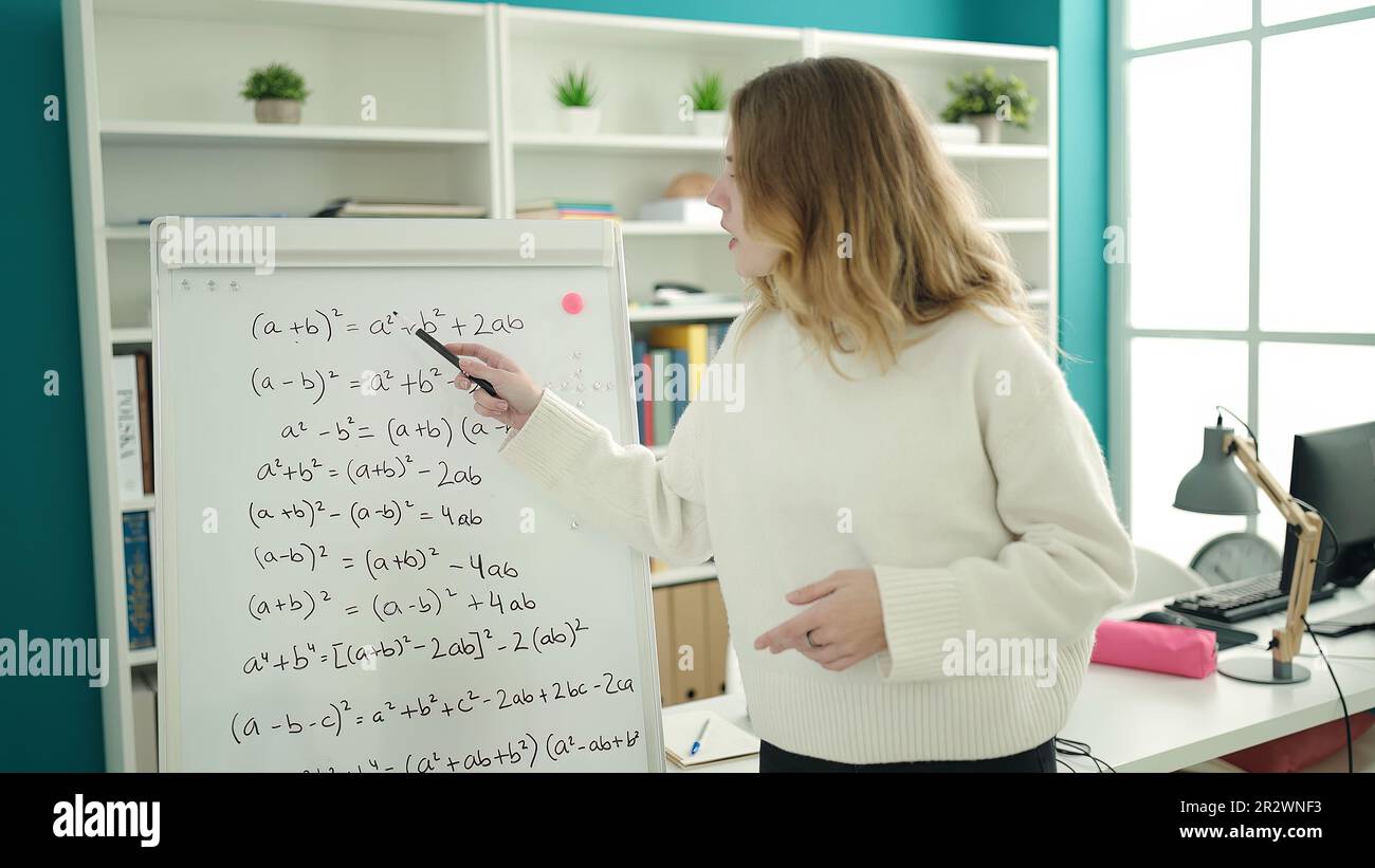 Young blonde woman teacher explaining maths exercise at university ...