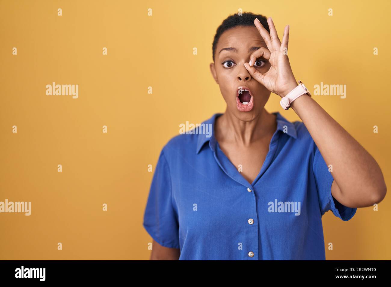 African american woman standing over yellow background doing ok gesture ...
