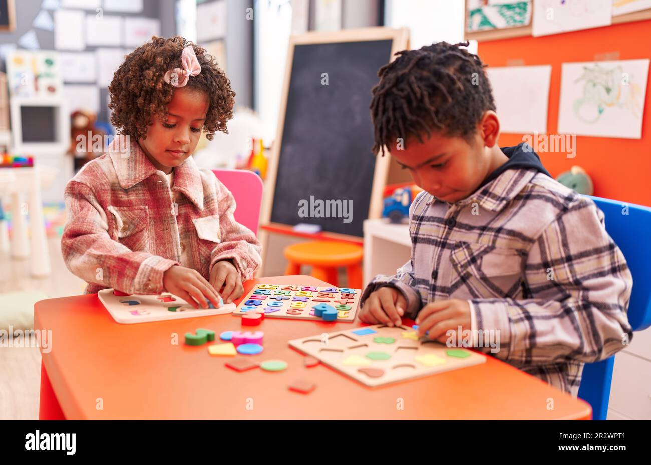 Adorable african american boy and girl playing with maths puzzle game ...