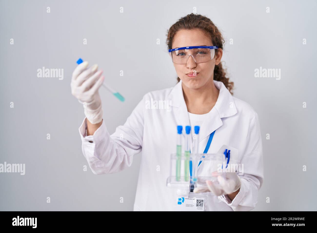 Young caucasian scientist woman working with laboratory samples puffing ...