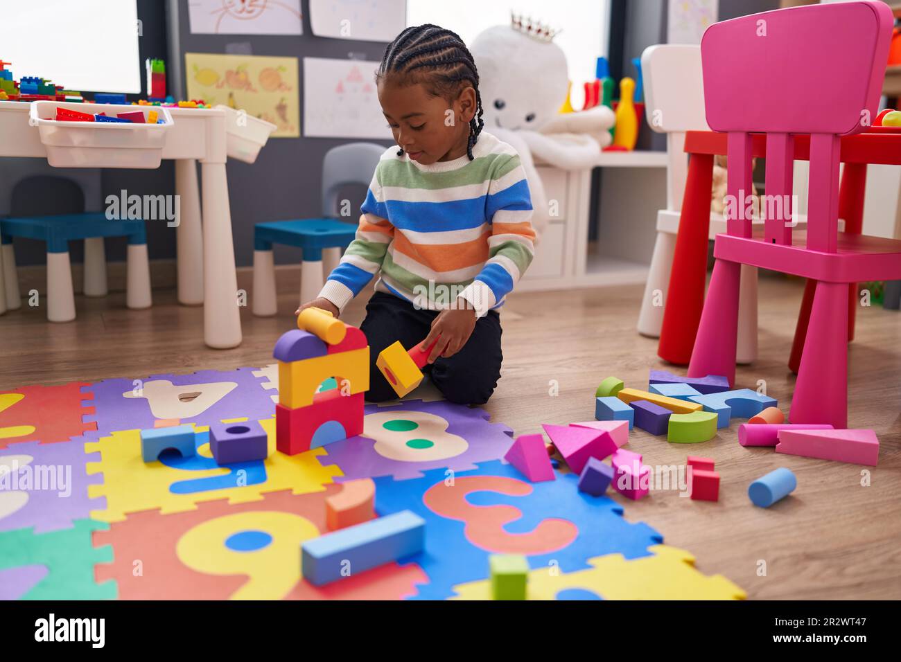 African american boy playing with construction blocks sitting on floor ...