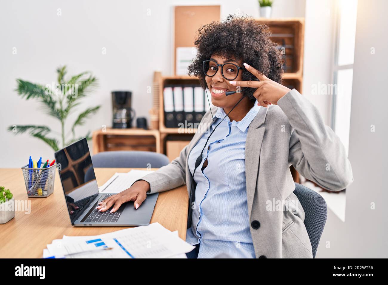 Black woman with curly hair wearing call center agent headset at the ...
