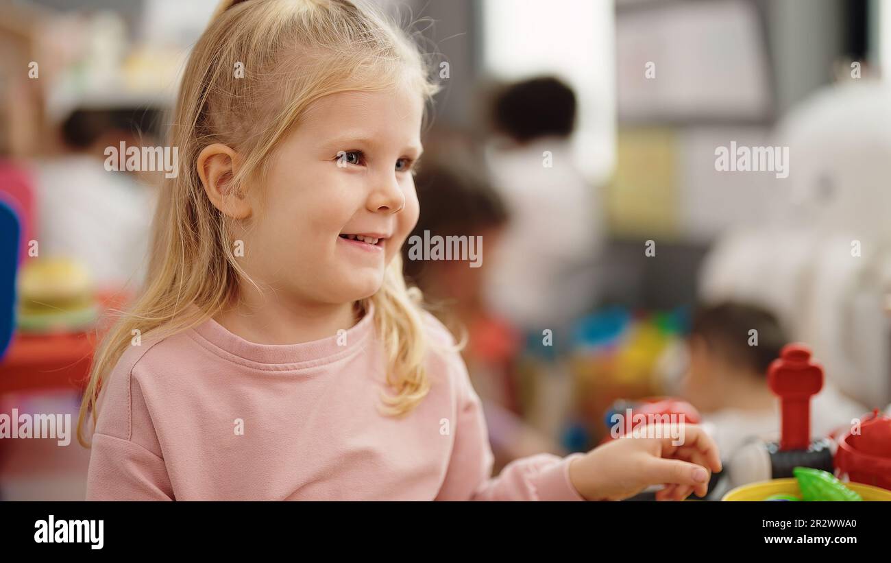 Adorable blonde girl smiling confident playing at kindergarten Stock Photo - Alamy