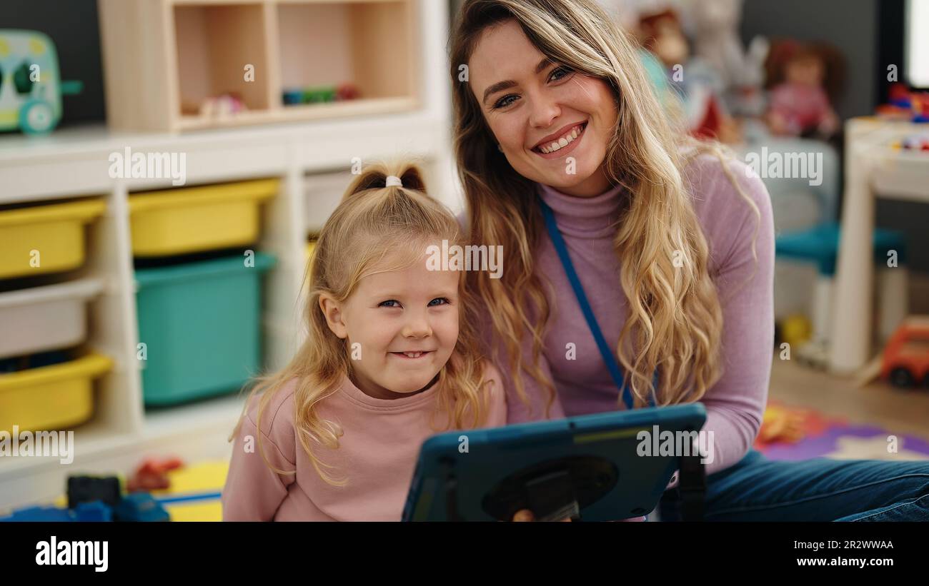 Woman and girl having lesson using touchpad at kindergarten Stock Photo ...