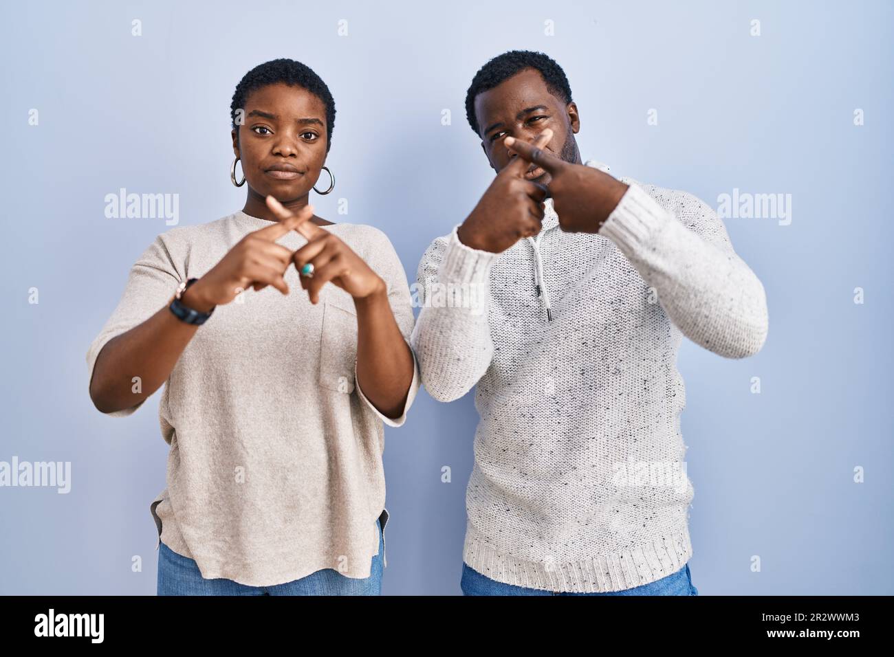 Young african american couple standing over blue background together ...