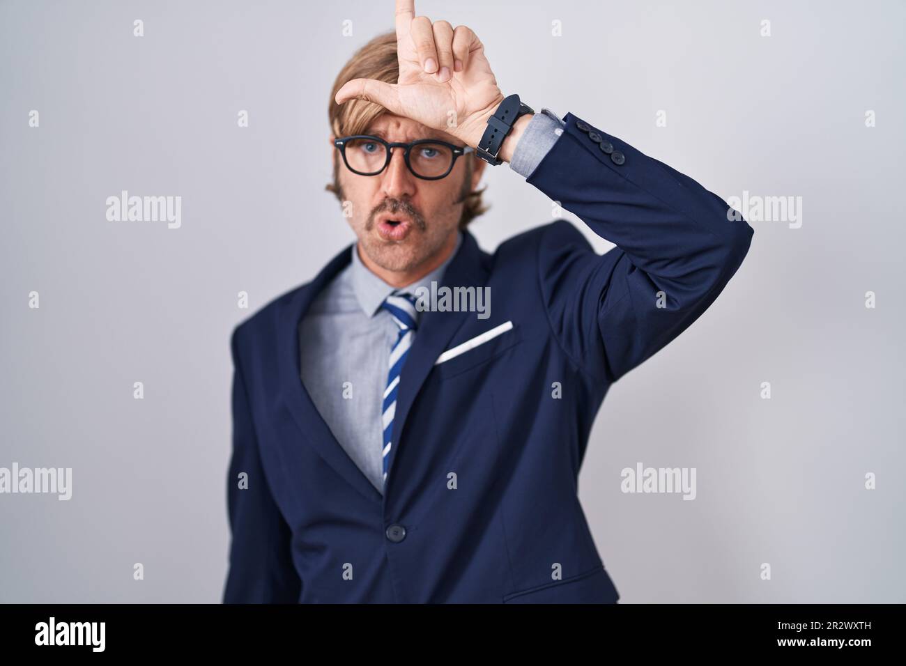 Caucasian man with mustache wearing business clothes making fun of ...