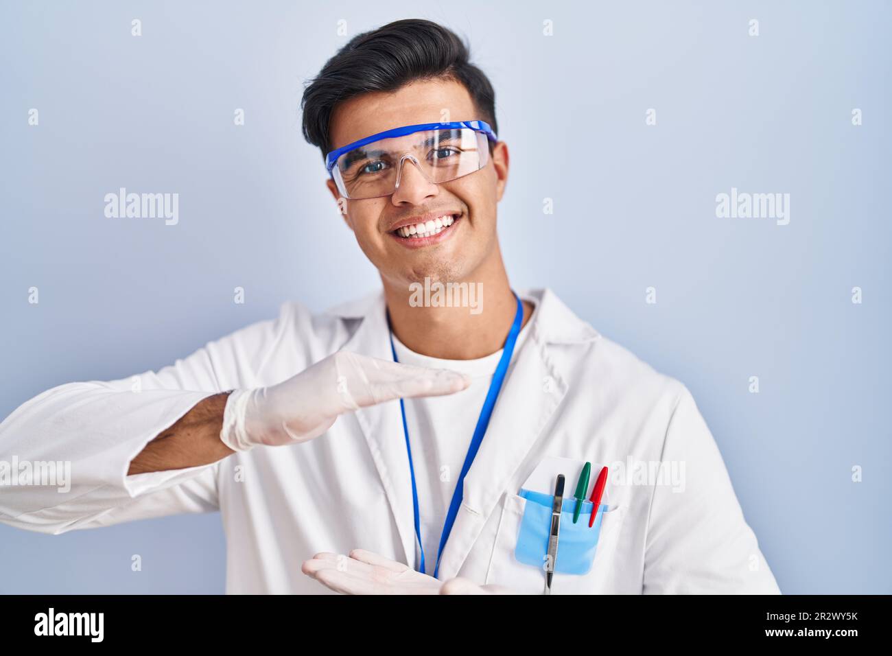 Hispanic man working as scientist gesturing with hands showing big and ...