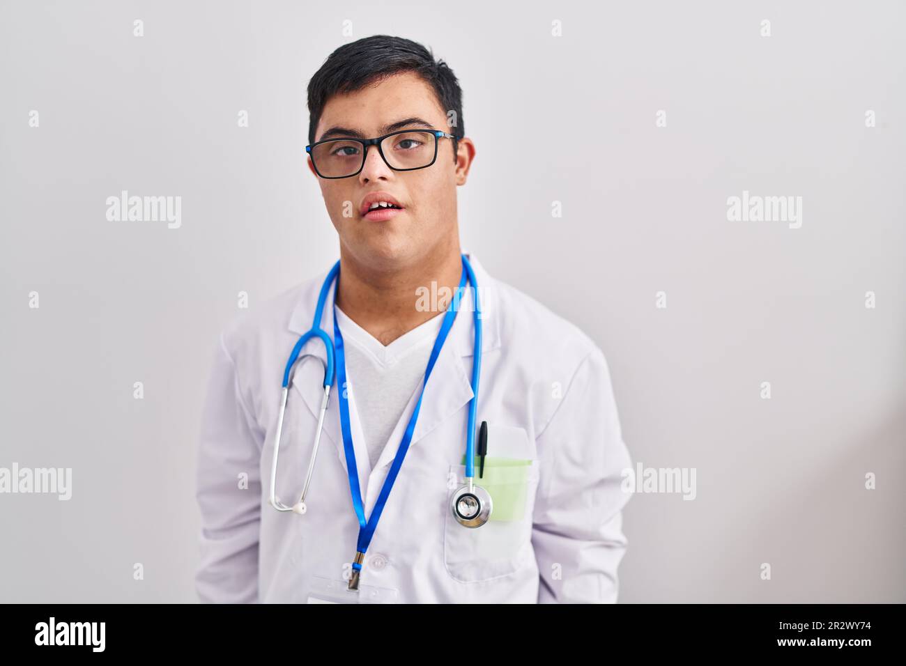 Young hispanic man with down syndrome wearing doctor uniform and ...