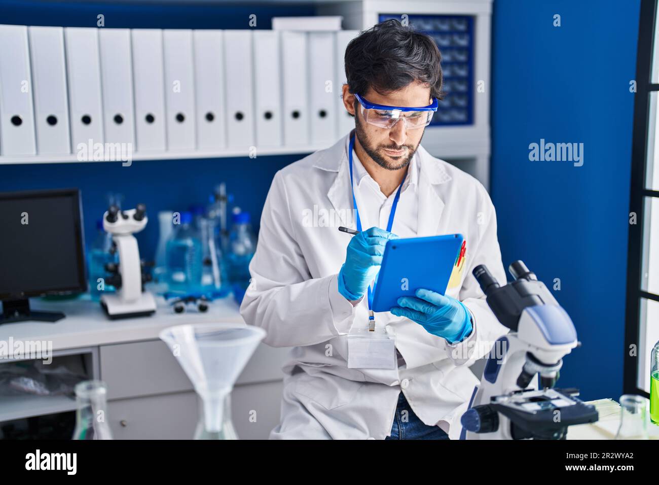 Young hispanic man scientist using touchpad at laboratory Stock Photo - Alamy