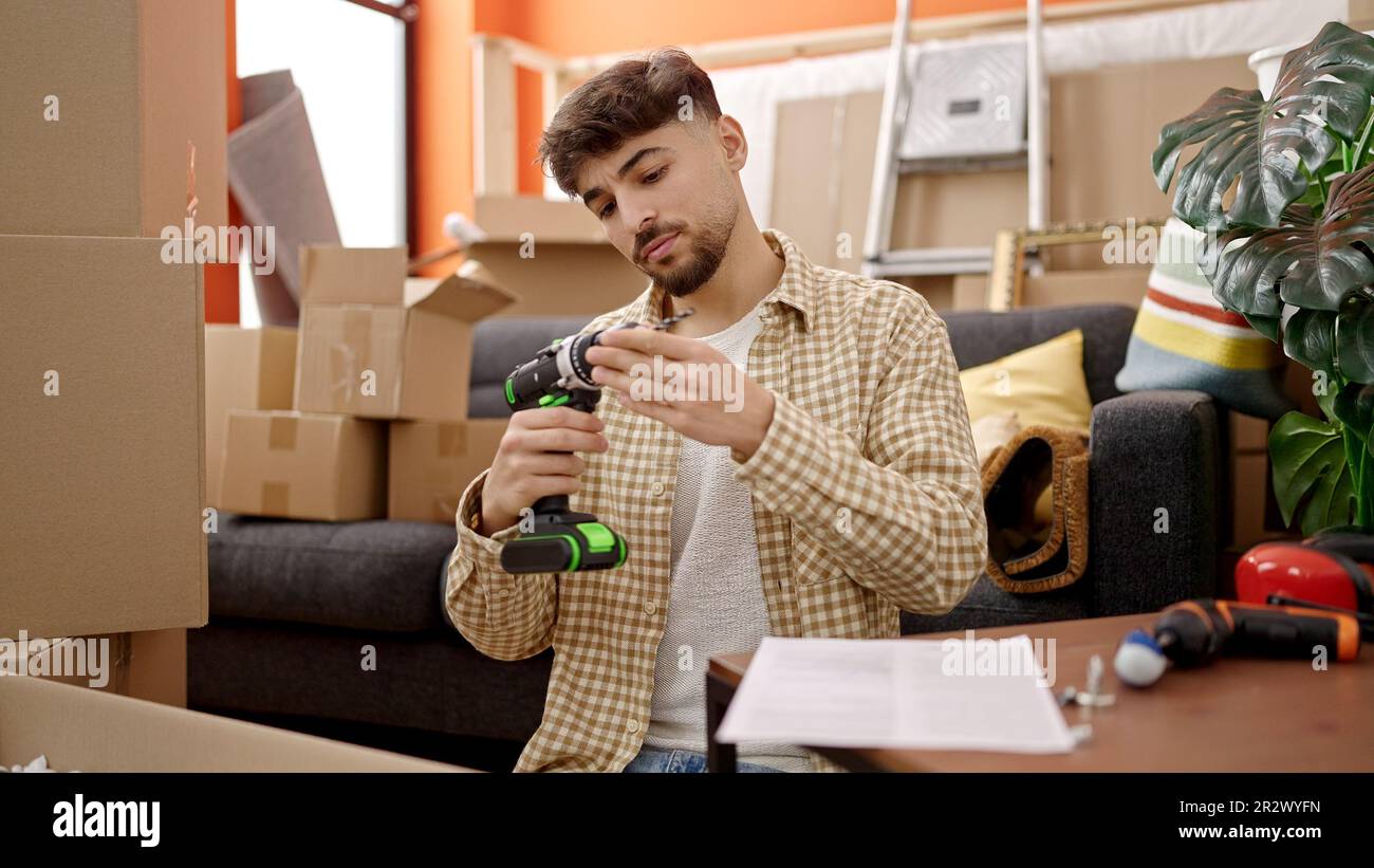 Young arab man repairing table using drill at new home Stock Photo - Alamy