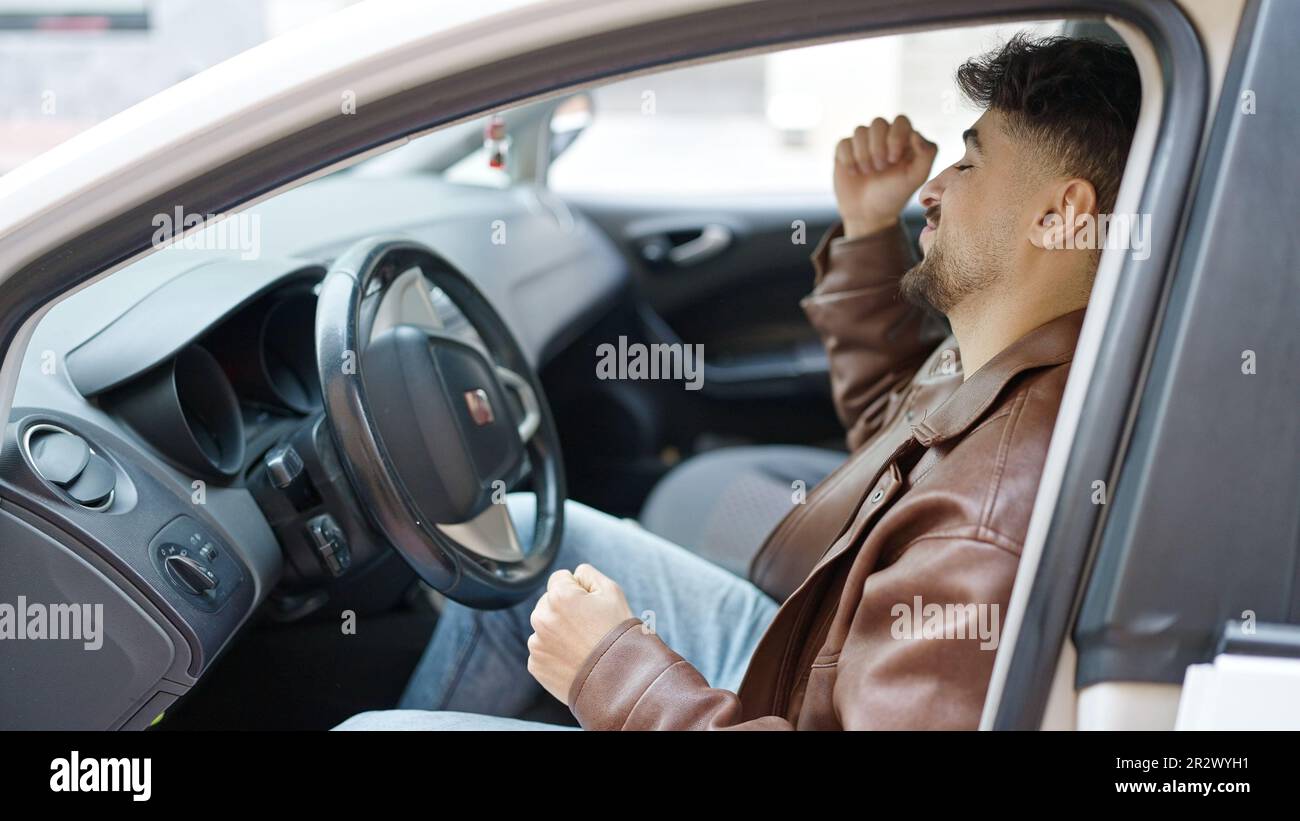 Young arab man sitting on car dancing at street Stock Photo - Alamy
