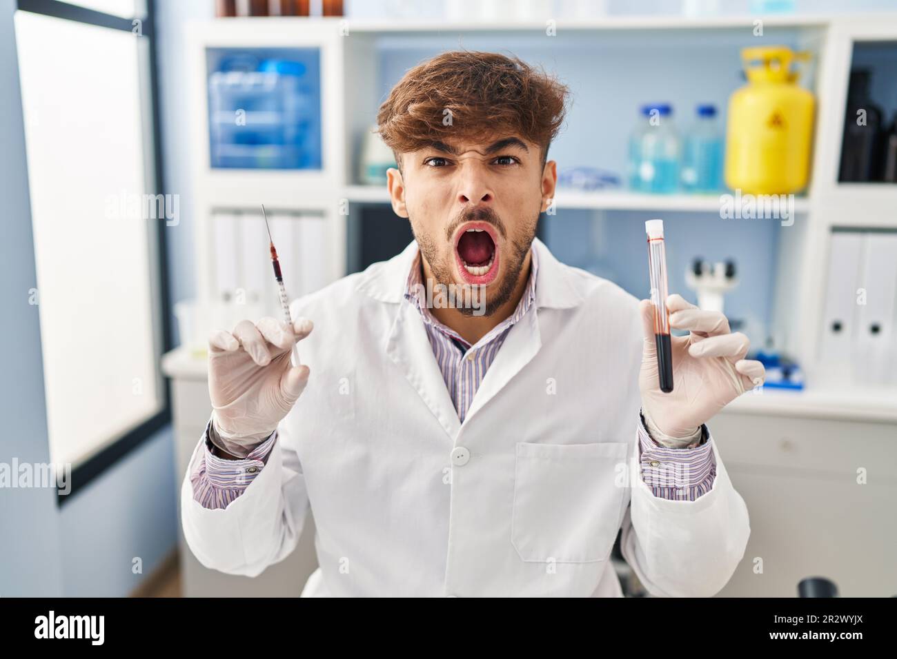Arab man with beard working at scientist laboratory holding blood ...