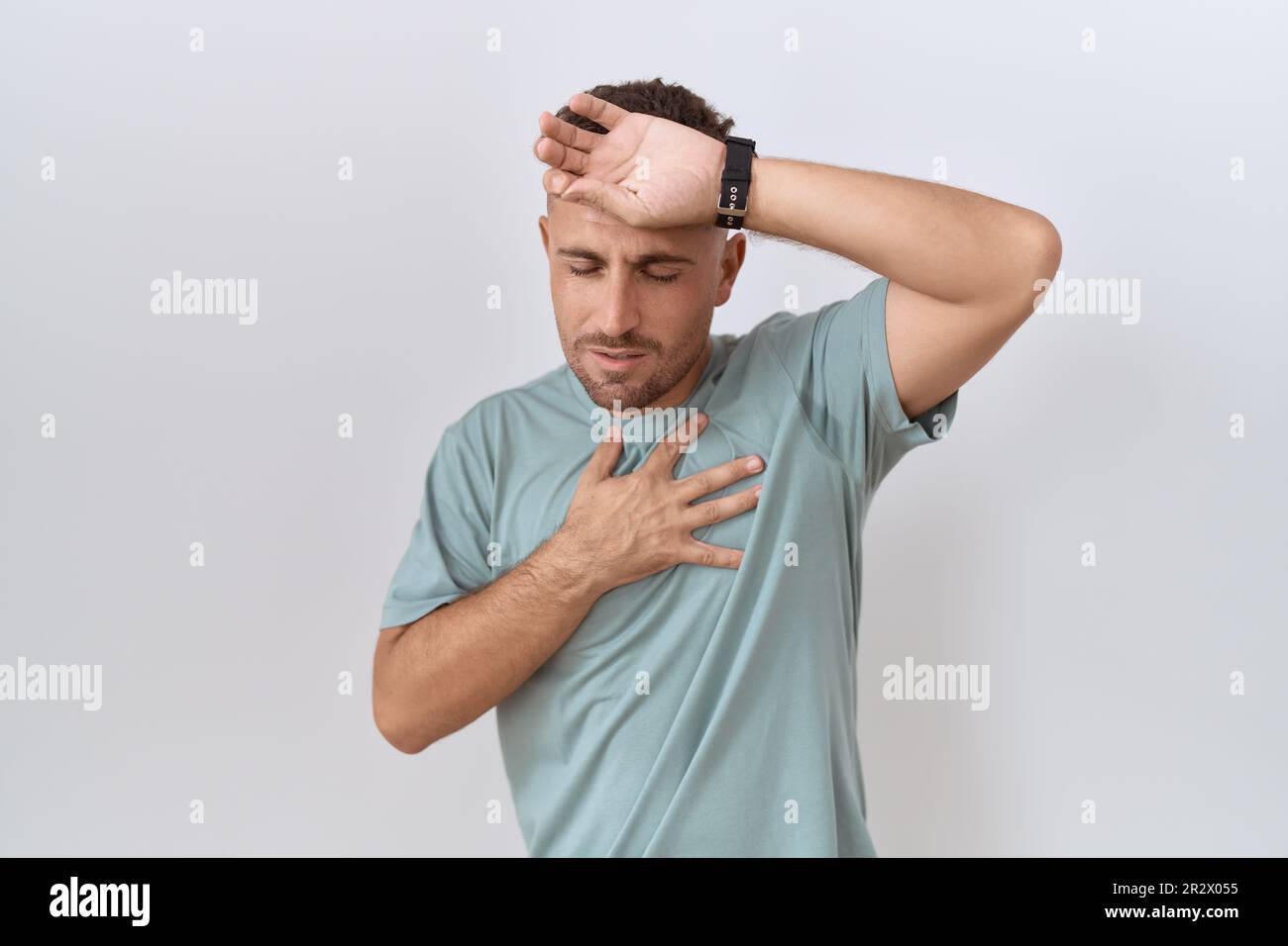 Hispanic man with beard standing over white background touching ...