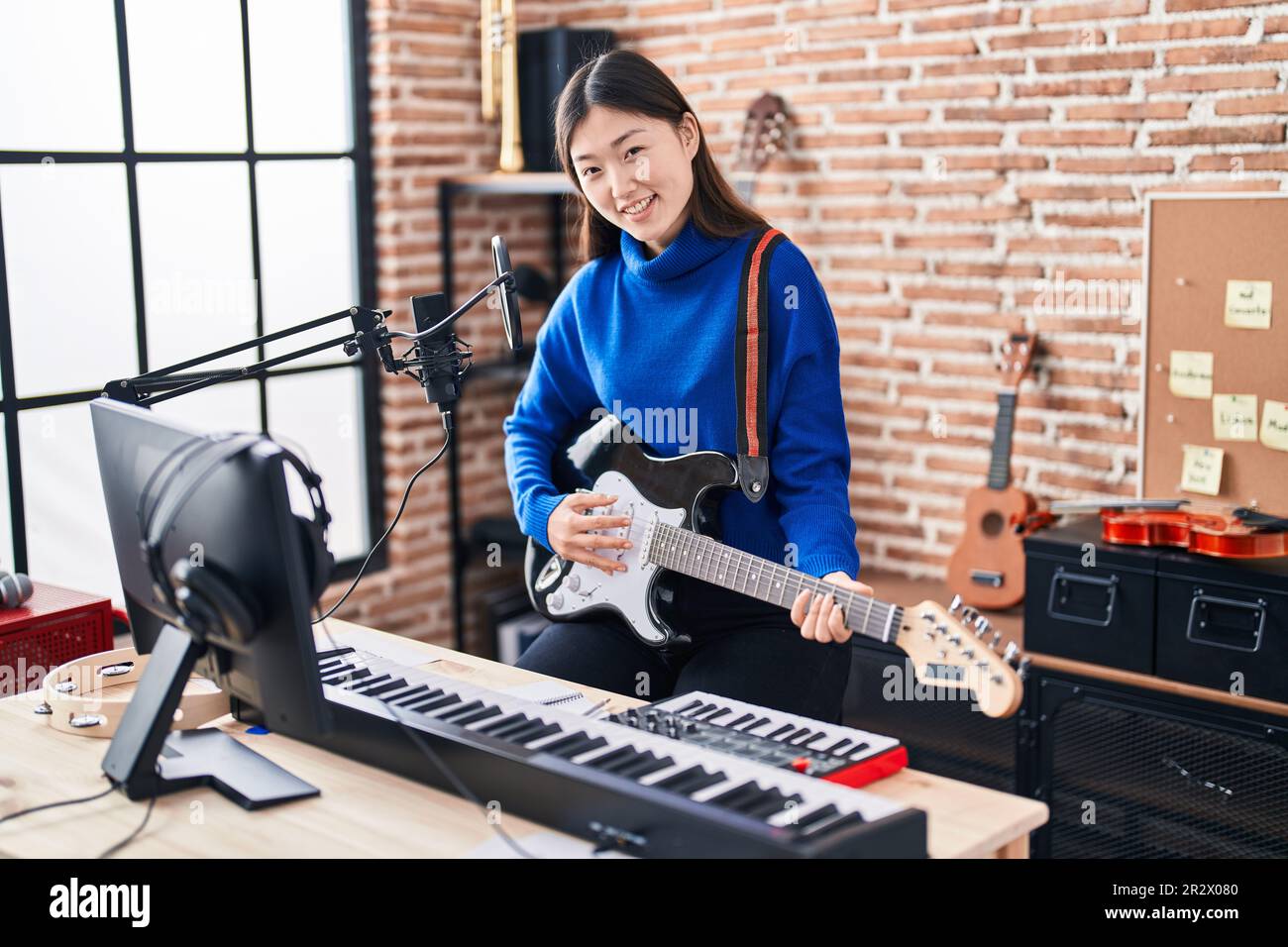 Chinese woman artist singing song playing electrical guitar at music ...