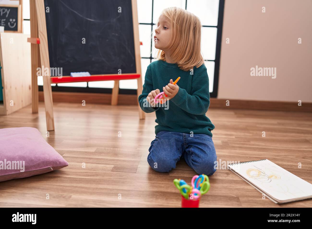 Adorable caucasian boy student holding scissors at kindergarten Stock ...