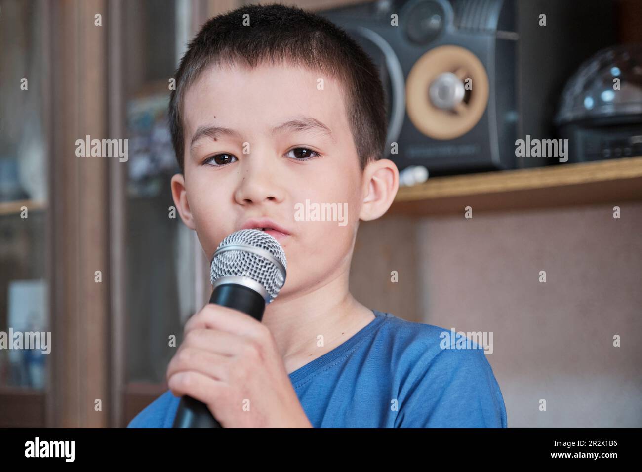 Close-up portrait of serious Asian boy looking at camera holding ...