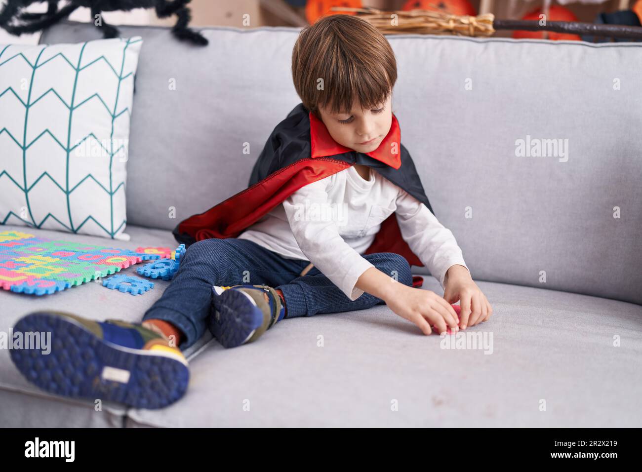 Adorable caucasian boy wearing vampire costume playing with vocabulary ...