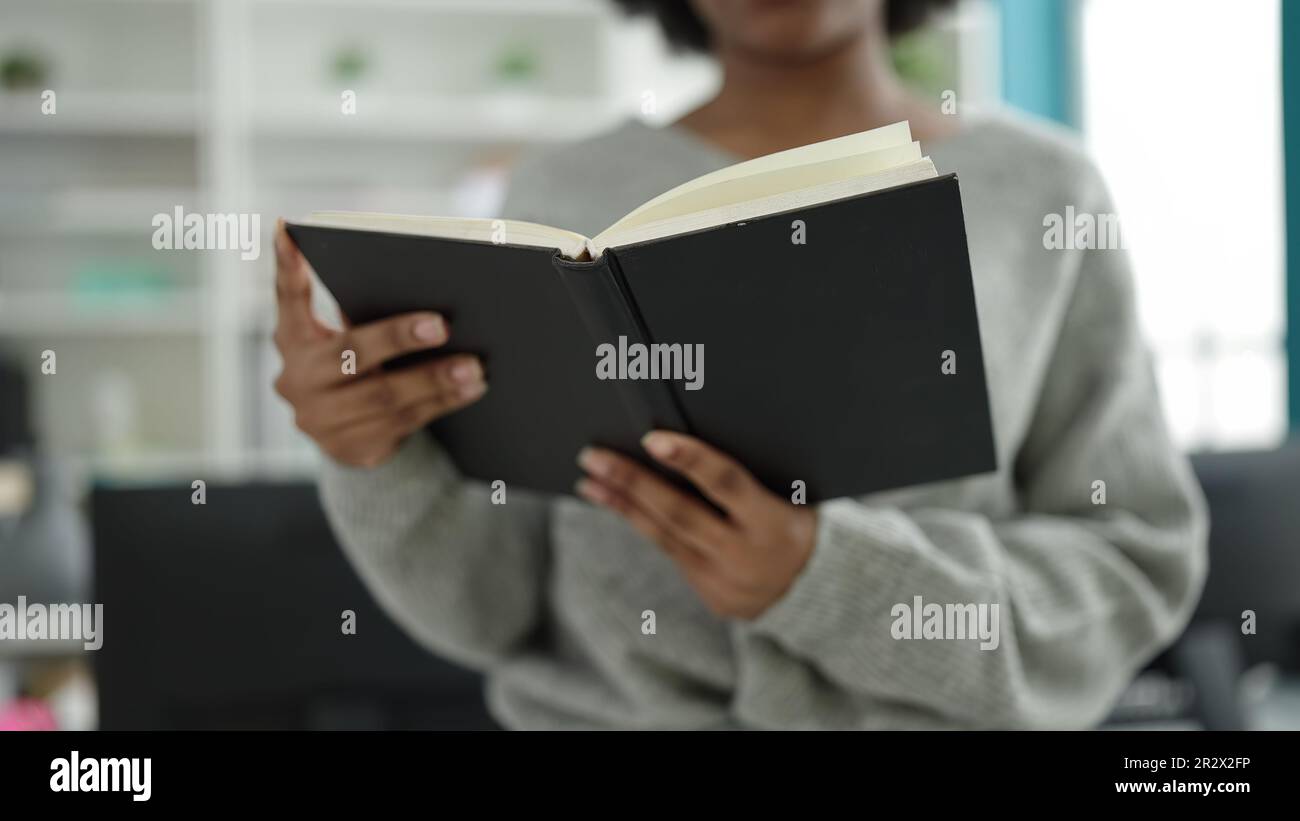 African american woman student reading book at library university Stock ...