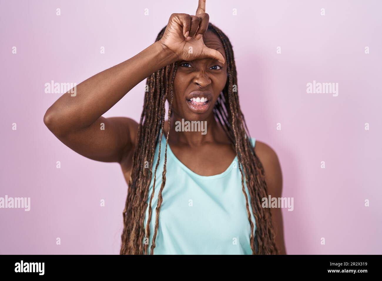 African american woman standing over pink background making fun of ...