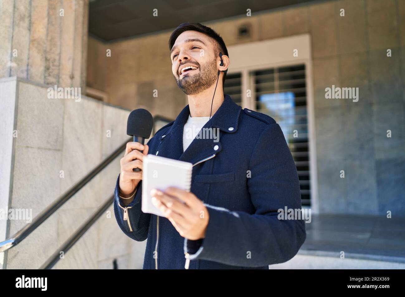 Young hispanic man reporter working using microphone at street Stock ...