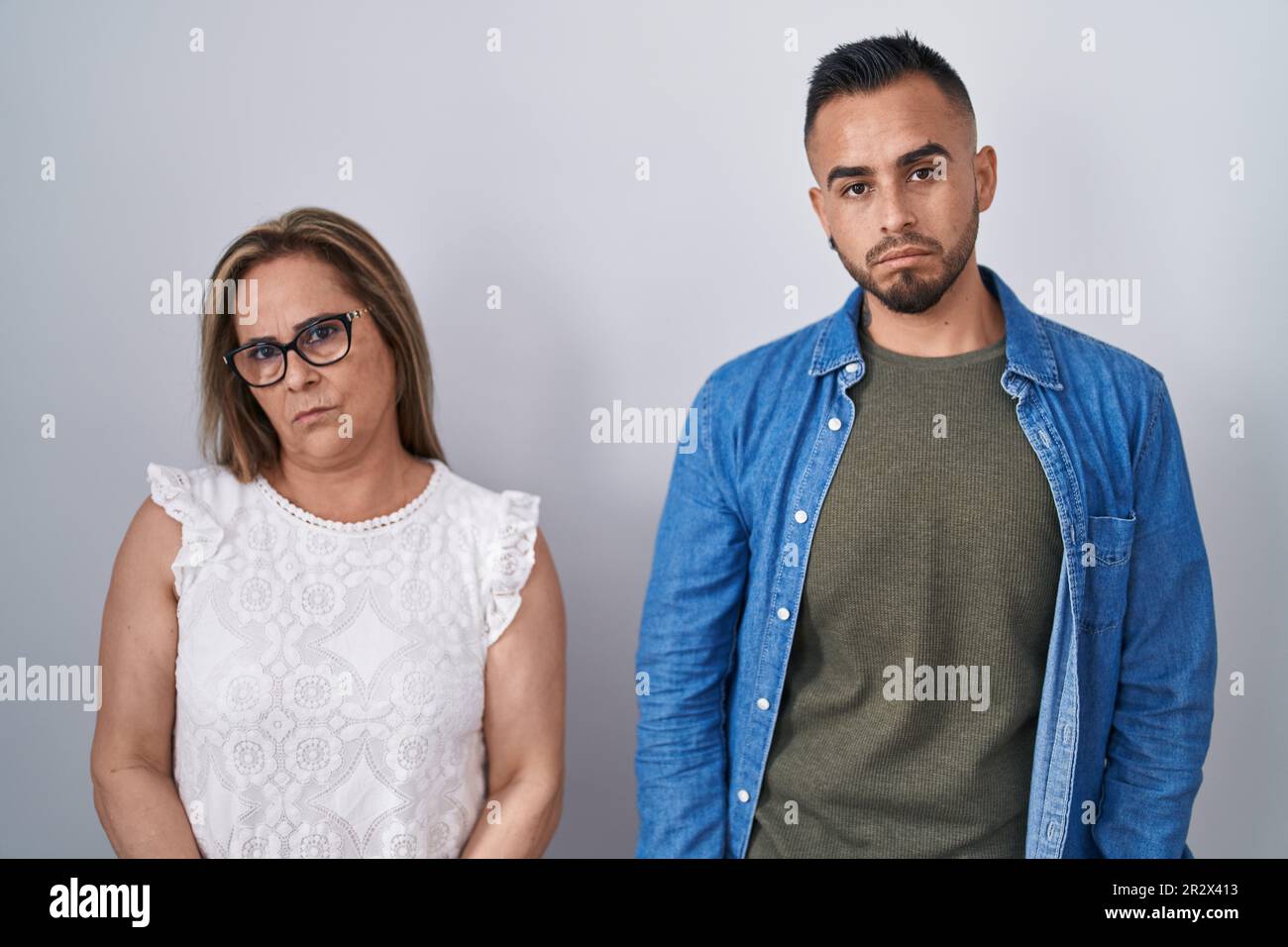 Hispanic mother and son standing together depressed and worry for ...