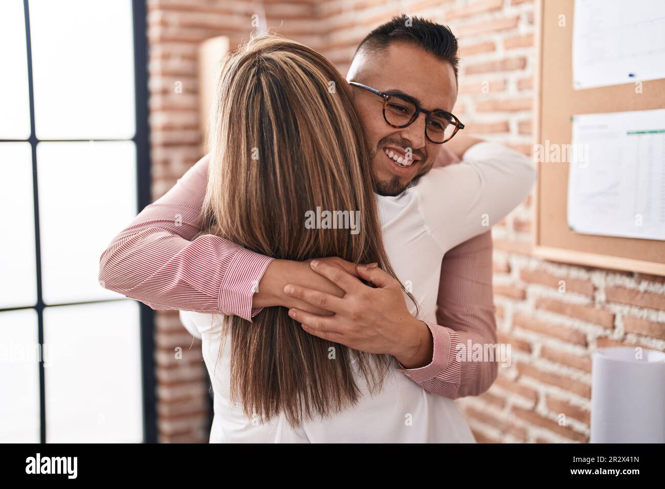 Man and woman business workers hugging each other at office Stock Photo ...