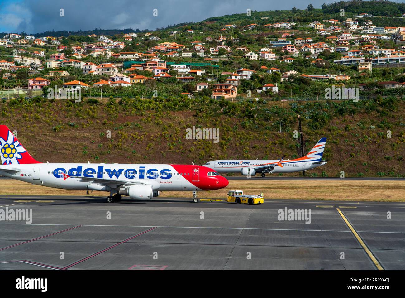 Edelweiss plane standing in front of the green hill with colorful ...