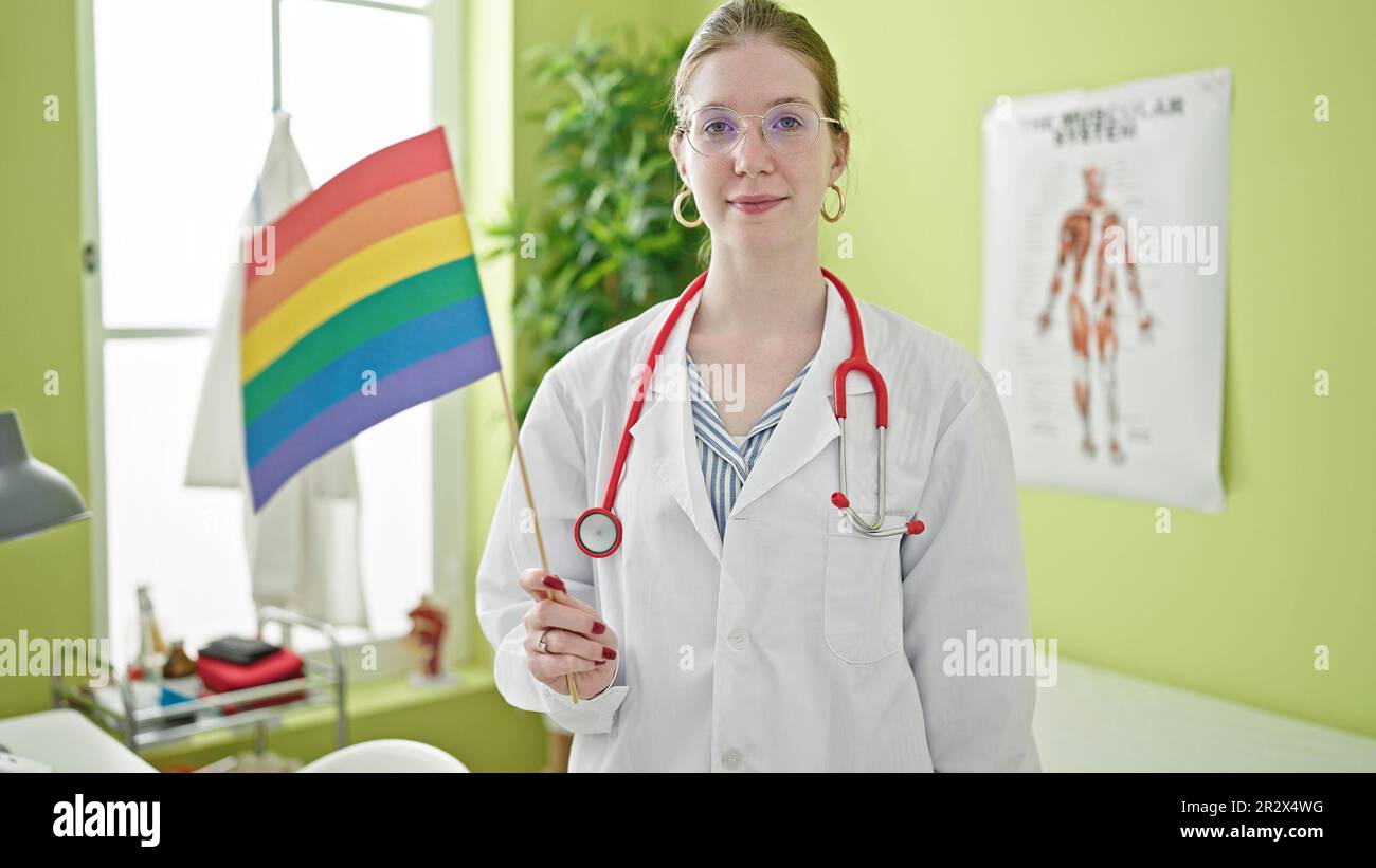 Young blonde woman doctor holding rainbow flag at clinic Stock Photo ...