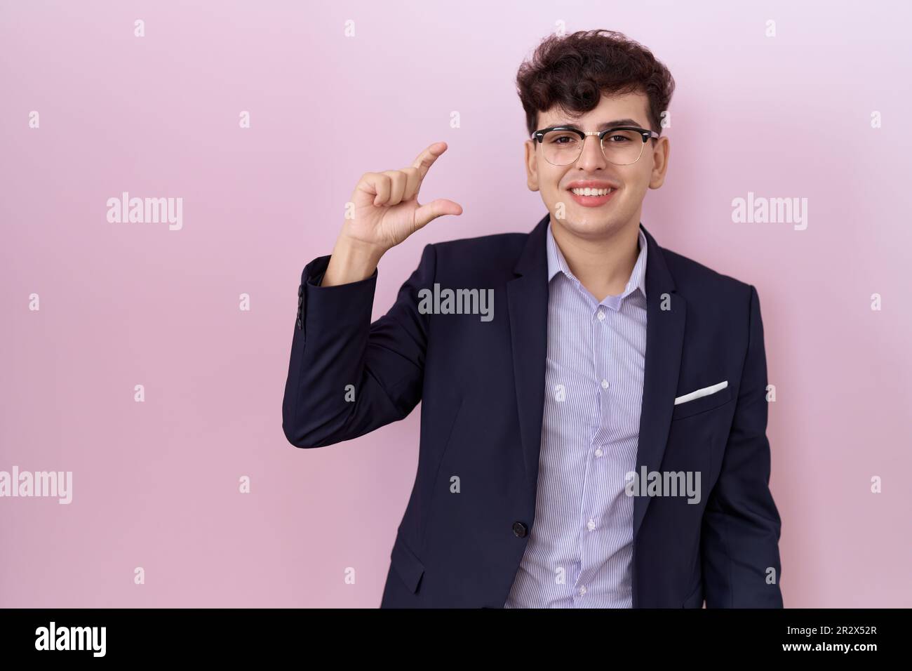 Young non binary man with beard wearing suit and tie smiling and ...