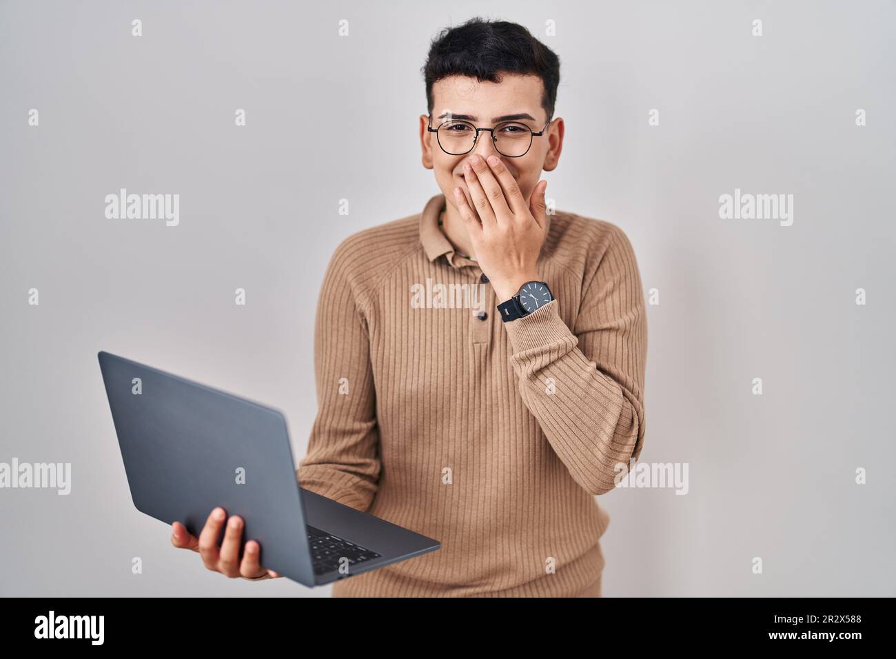 Non binary person using computer laptop laughing and embarrassed giggle ...