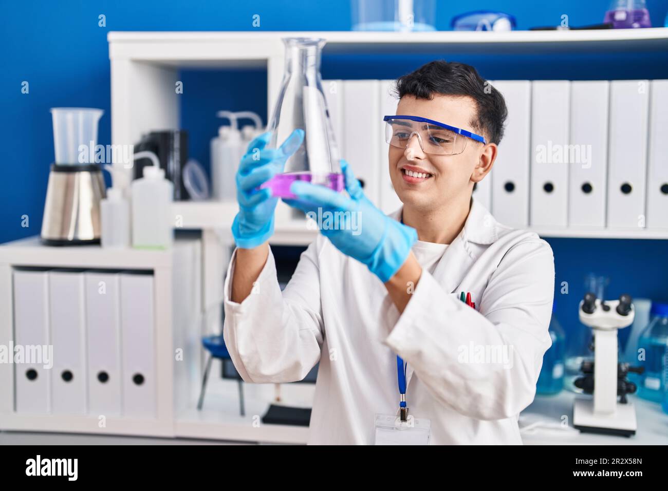 Young non binary man scientist smiling confident measuring liquid at laboratory Stock Photo - Alamy