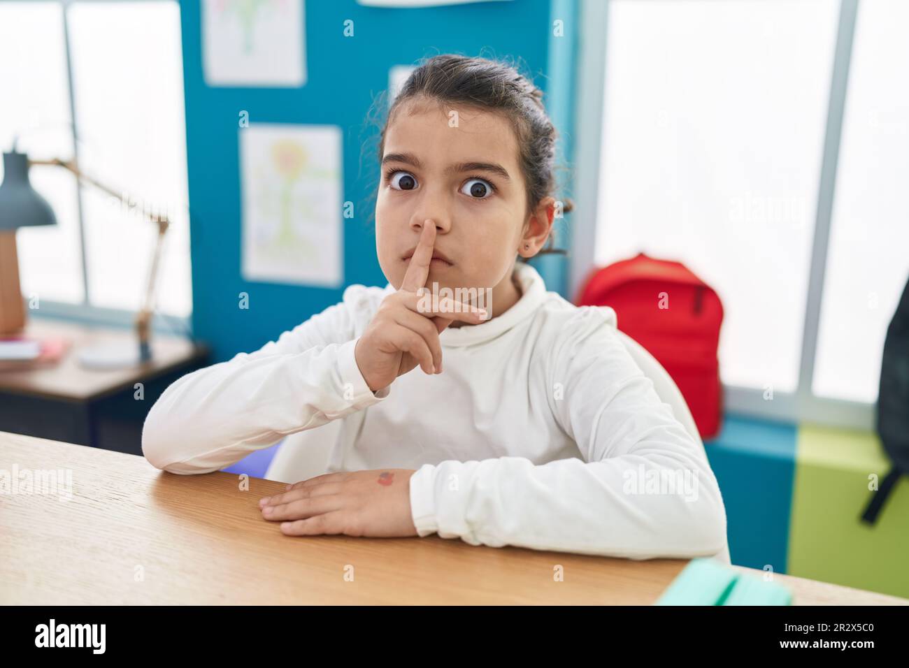 Adorable hispanic girl student asking for silence at classroom Stock ...