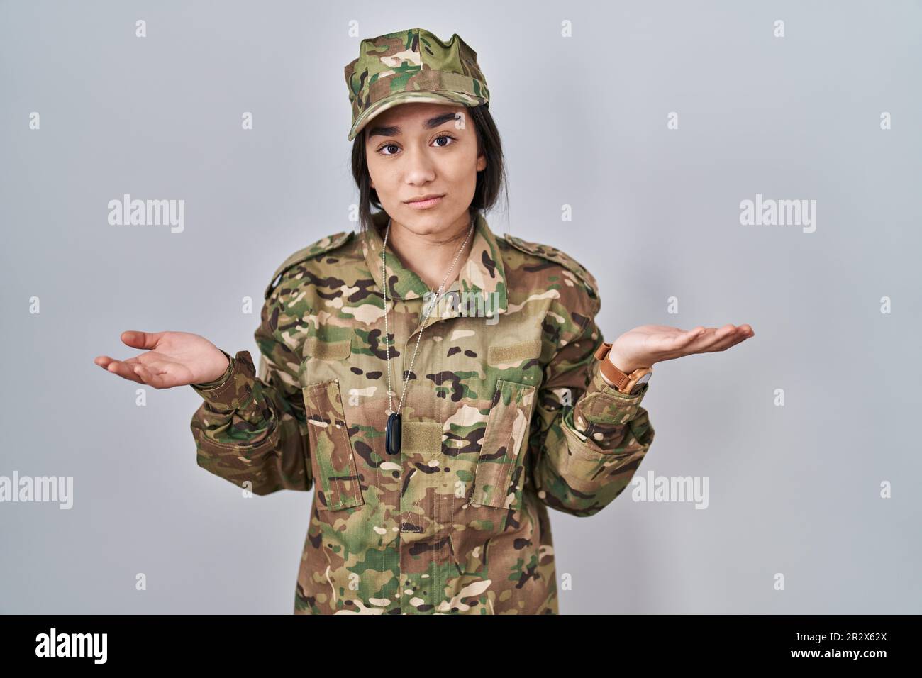 Young south asian woman wearing camouflage army uniform clueless and ...