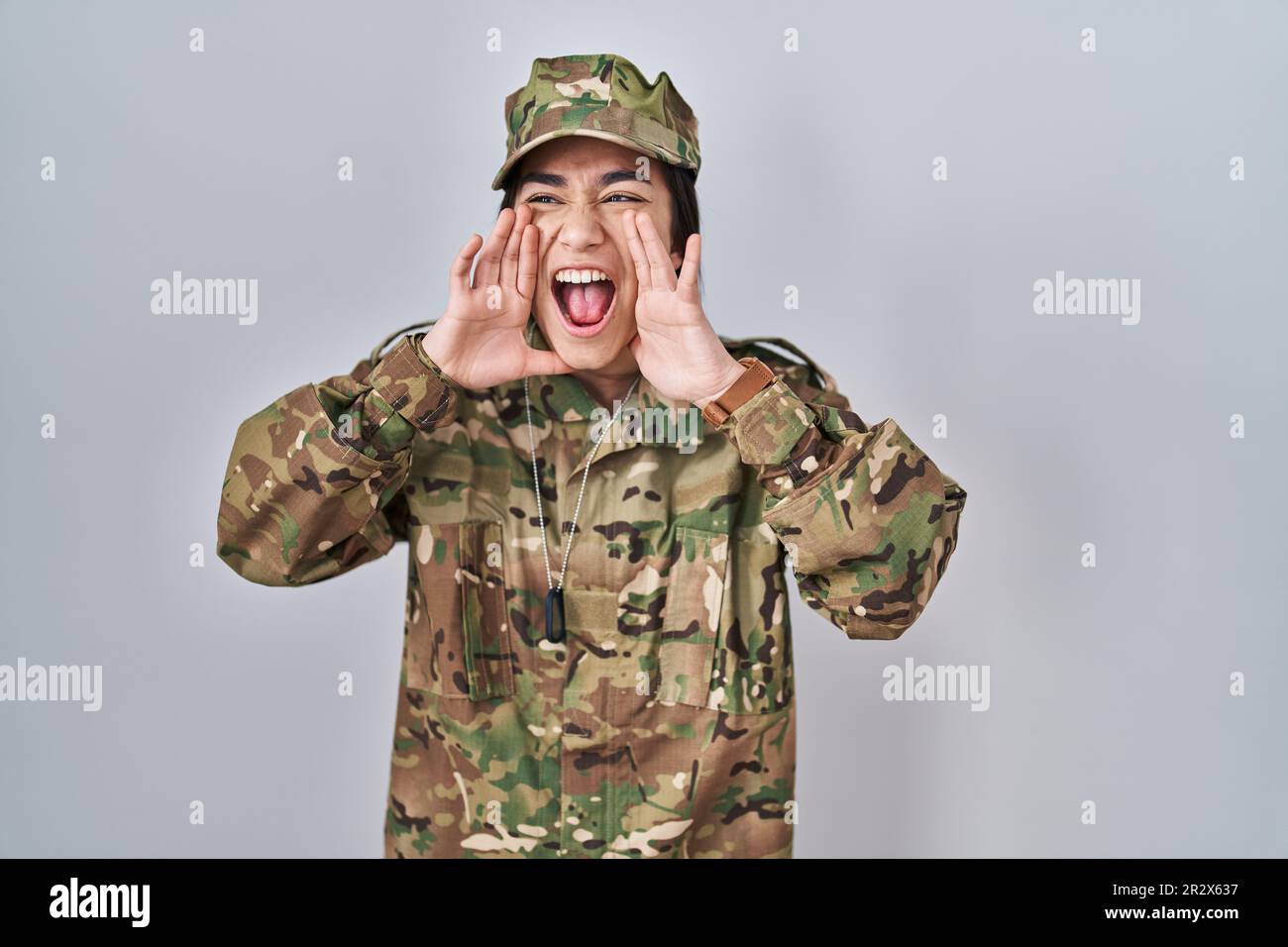 Young south asian woman wearing camouflage army uniform shouting angry ...