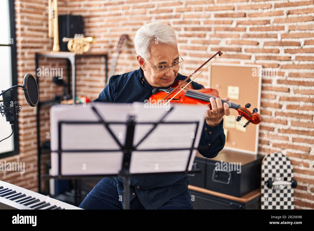Senior man musician playing violin at music studio Stock Photo - Alamy