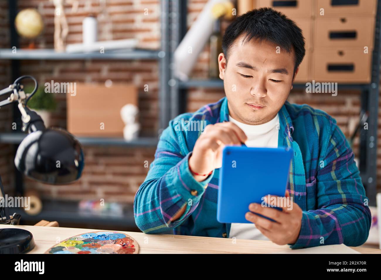 Young chinese man artist using touchpad at art studio Stock Photo - Alamy