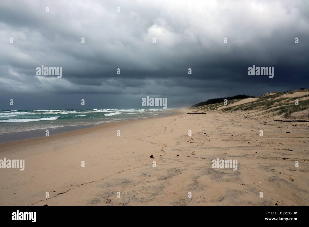 view along empty beach under a stormy sky Main Beach, North Stradbroke ...