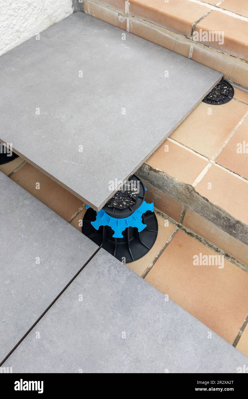 Exterior plots pavement grey tiles installation on the house terrace ...