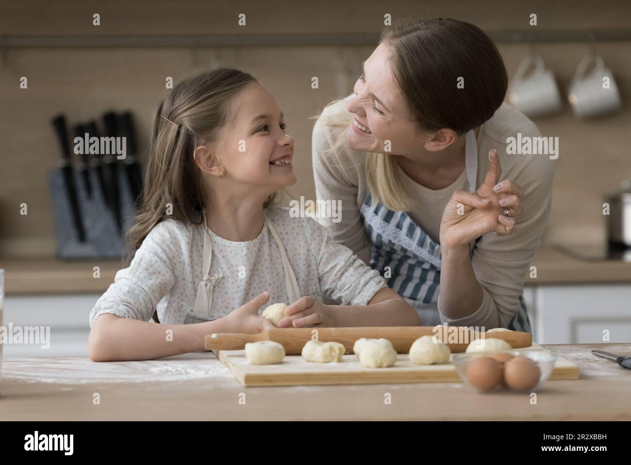 Loving mom and little daughter prepare pastries for family breakfast ...
