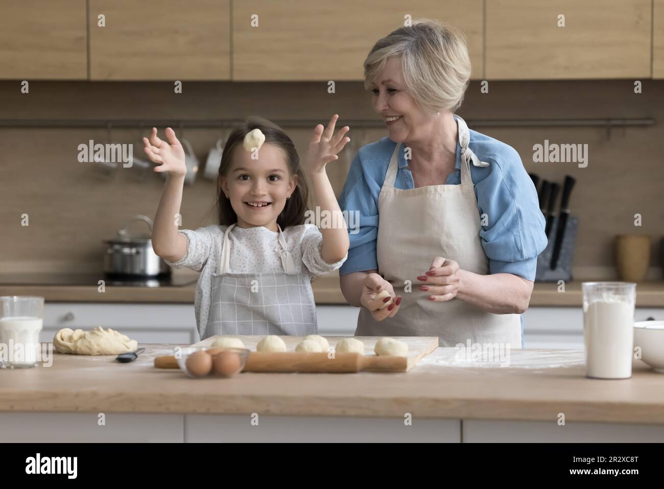 Happy child throwing dough looks playful white cooking with grandma ...
