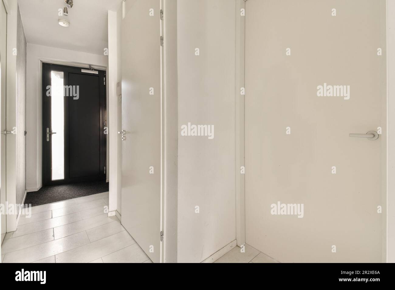 an empty room with white walls and black door handles on the left side ...