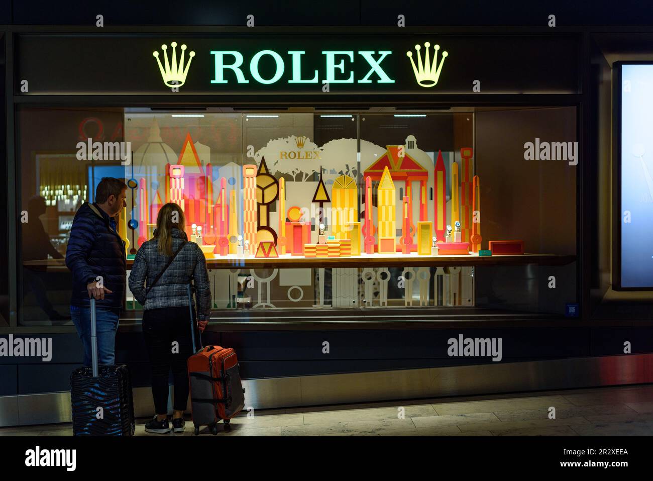 A couple is seen looking at the window of luxury watches brand Rolex ...