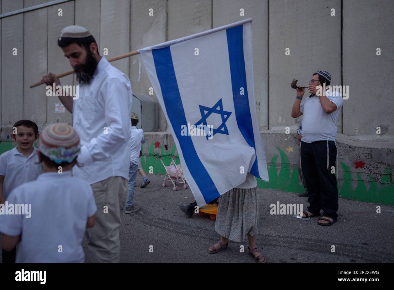 Religious Israeli Jews hold the national flag and dance during a ...