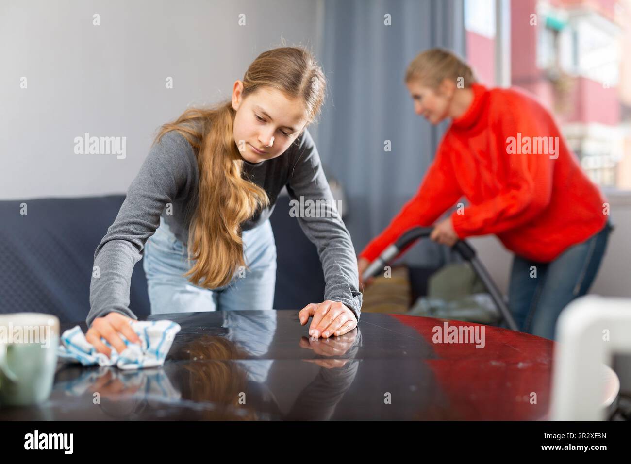 Teenage girl cleaning table with rag Stock Photo - Alamy