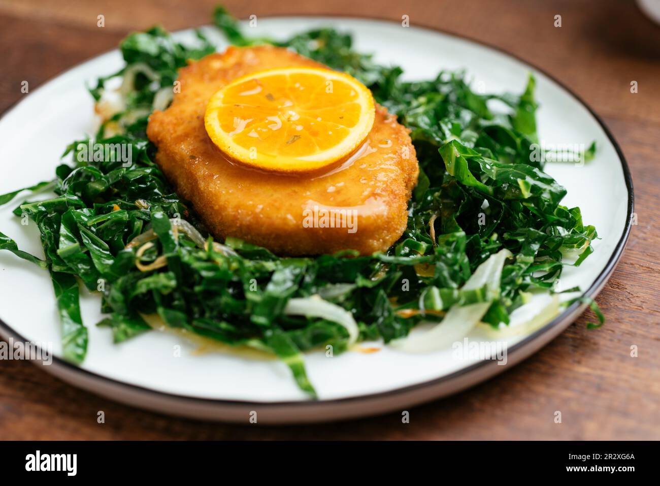 Plate of a vegan Schnitzel on sauteed savoy cabbage with a chili orange ...