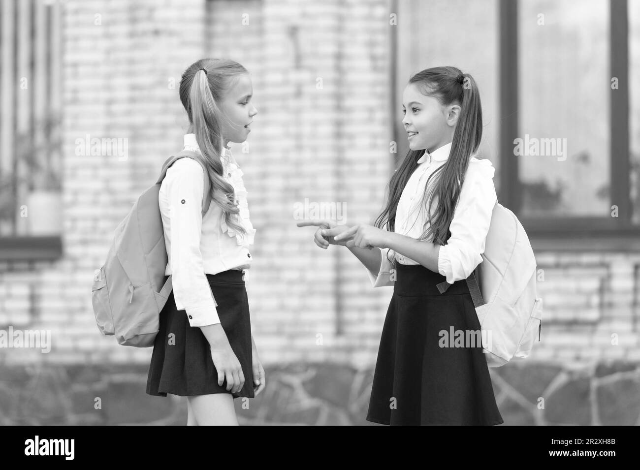 two school girls friends talking together duting school break Stock ...
