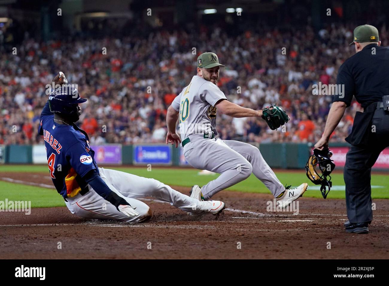 Houston Astros' Yordan Alvarez, left, scores as Oakland Athletics ...