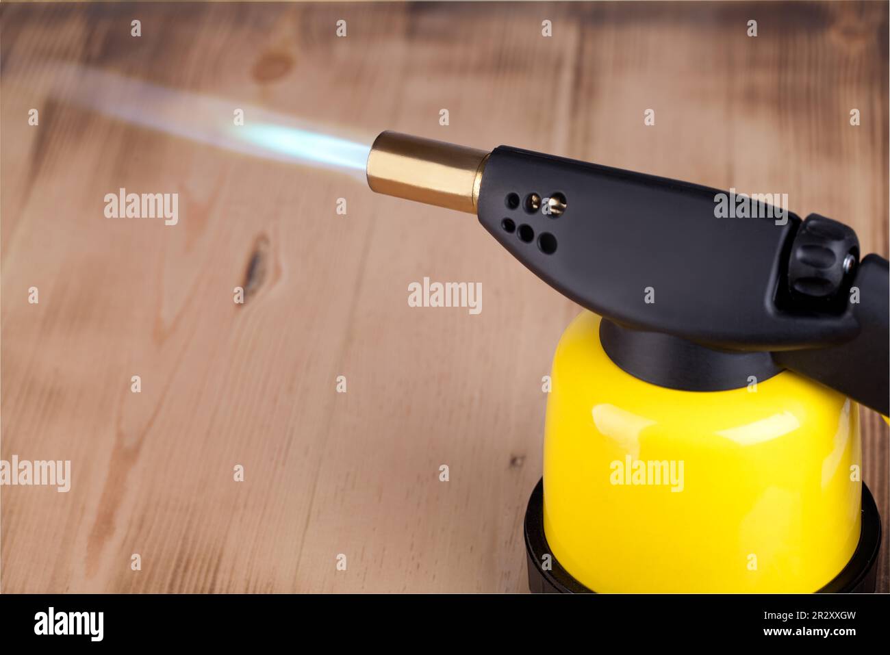 manual gas burner on a wooden background Stock Photo - Alamy