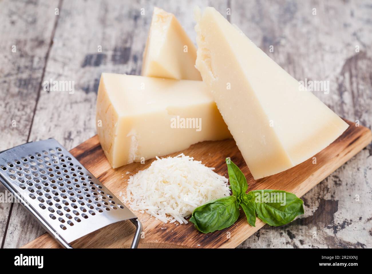 grated parmesan cheese and metal grater on wooden board Stock Photo - Alamy